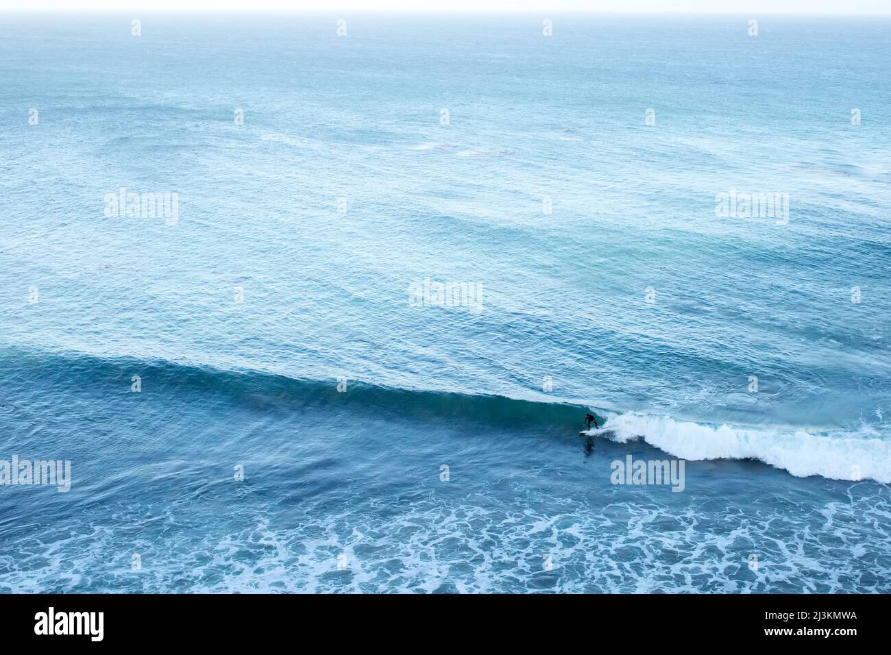 A lone surfer rides a Pacific wave Stock Photo - Alamy