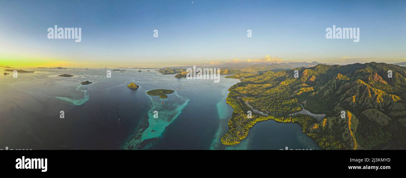 Aerial view of the Komodo Islands with bright yellow sunlight on the ...