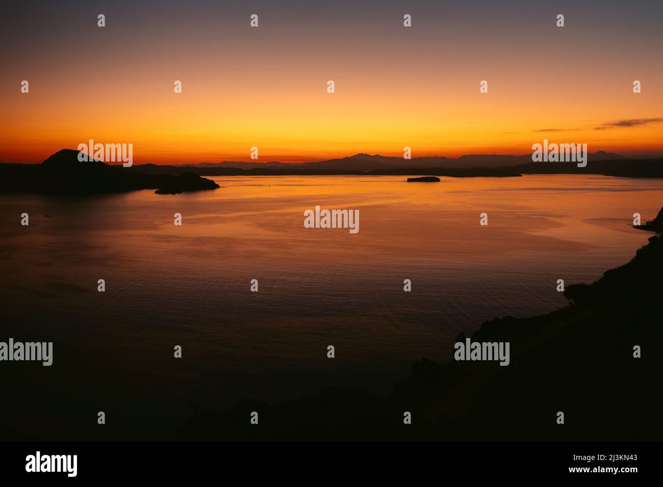 Bright yellow and orange glow of the sunset over the ocean and ...