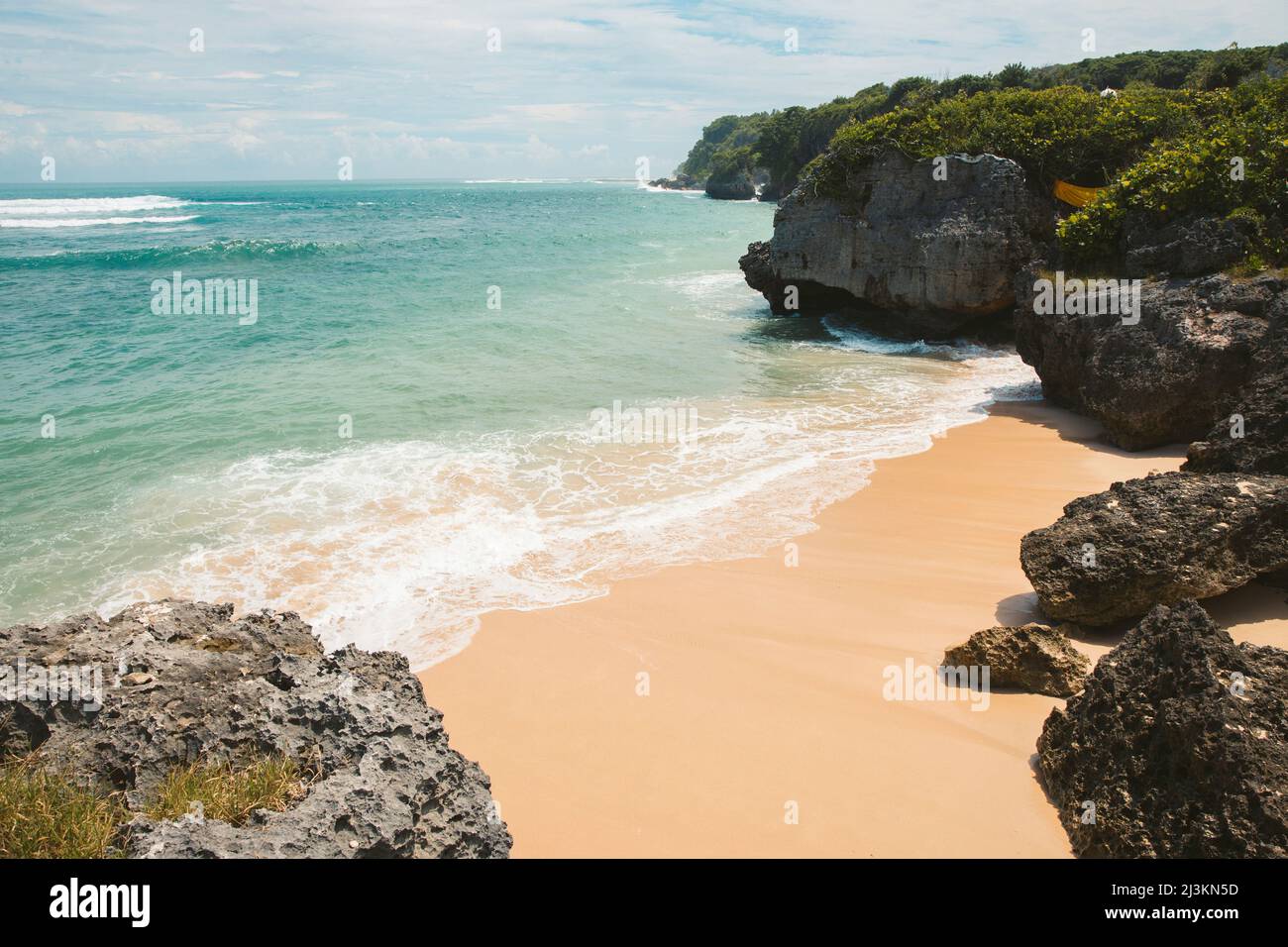 Ocean waves and rocky coast with the surf rolling onto the sand at ...