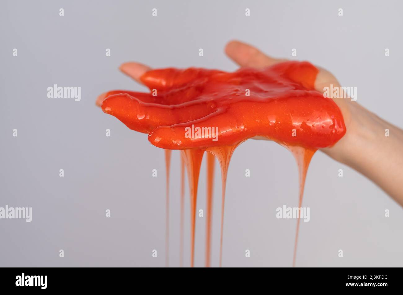 Red slime flowing down from a woman's hand on a white background Stock ...