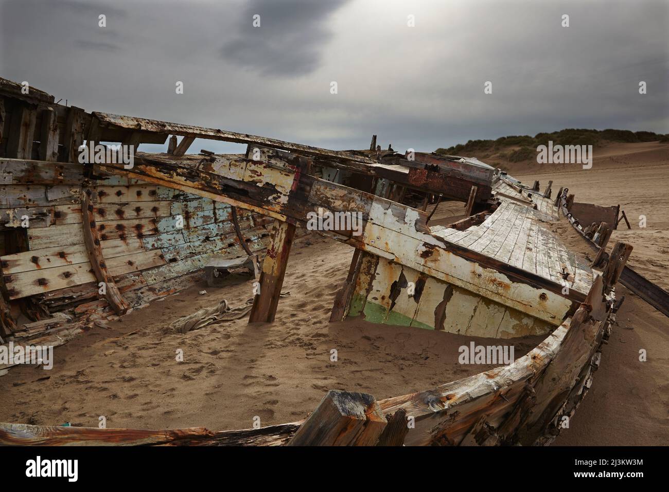 Weathered shipwreck lying in sand dunes at Crow Point, at the mouth of ...