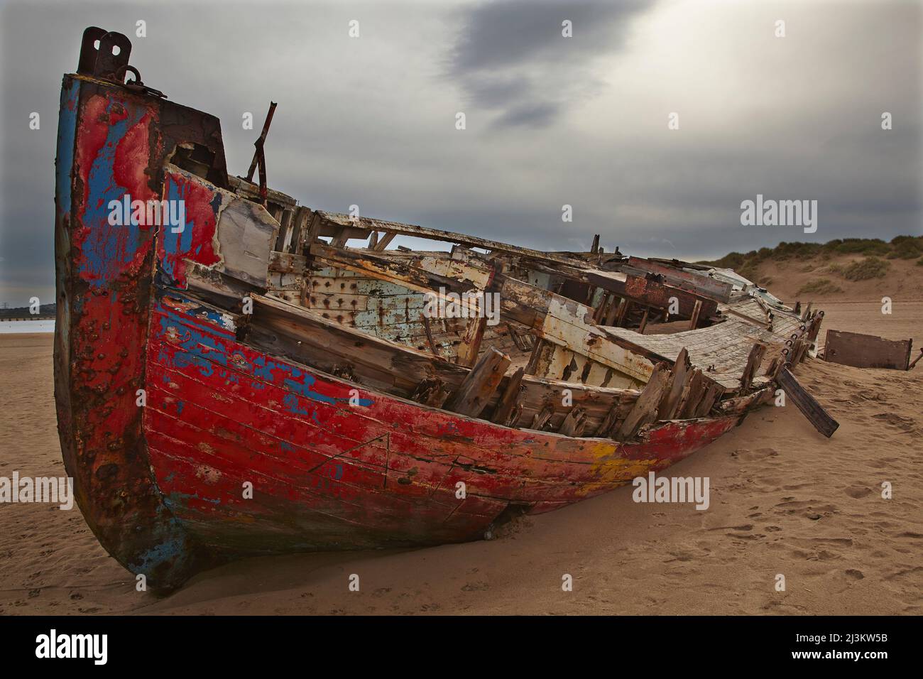 Colourful weathered shipwreck lying in sand dunes at Crow Point, at the ...