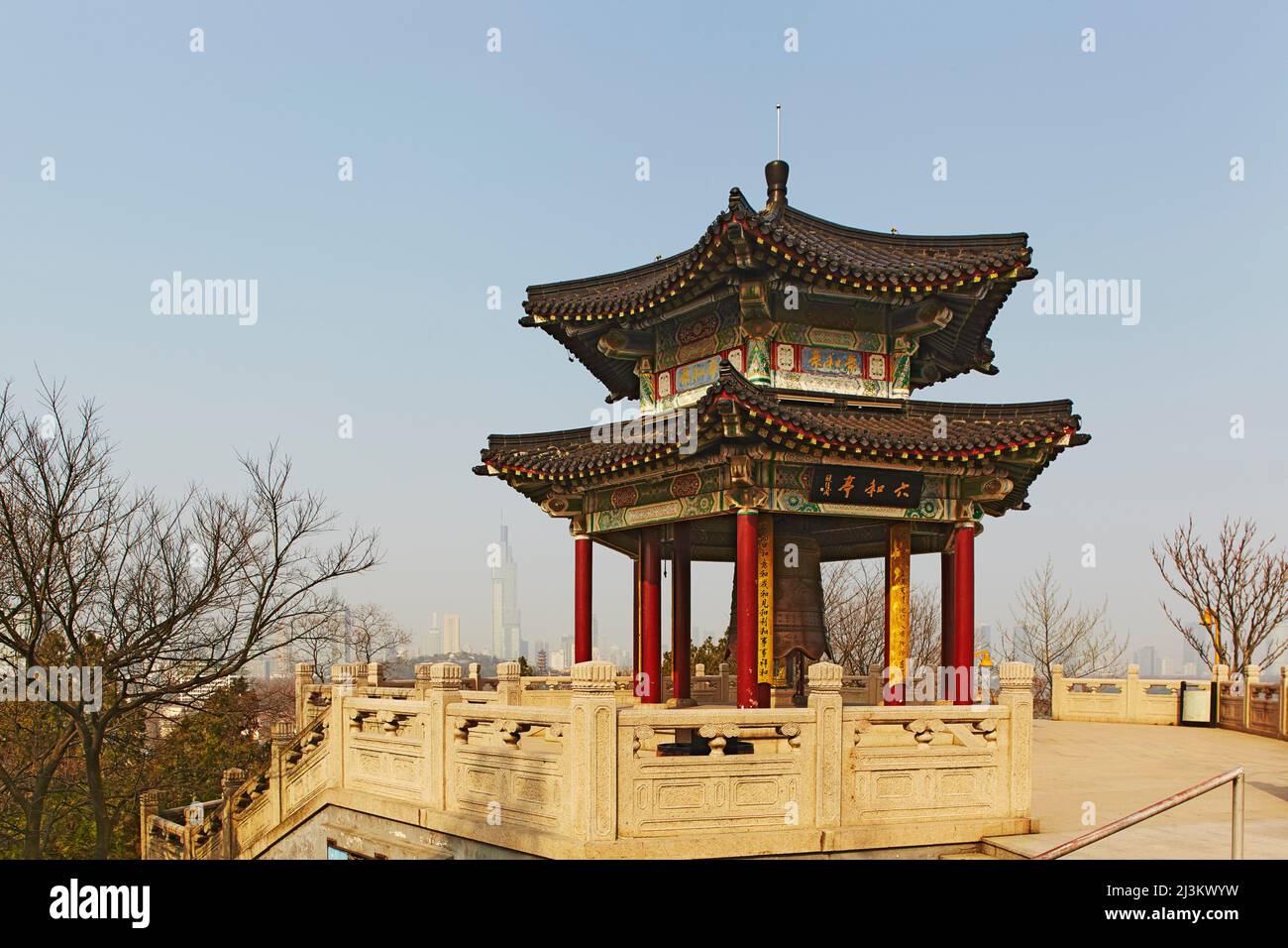 A traditional bell tower pavilion at Jiuhuashan Temple with the modern ...