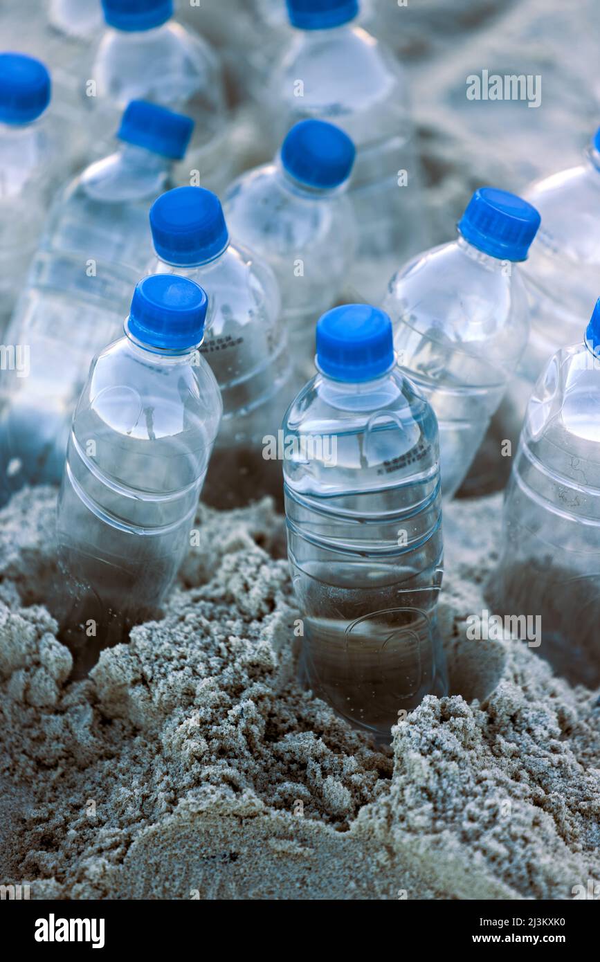 Time to put a cap on pollution. Shot of bottles laying on the beach ...