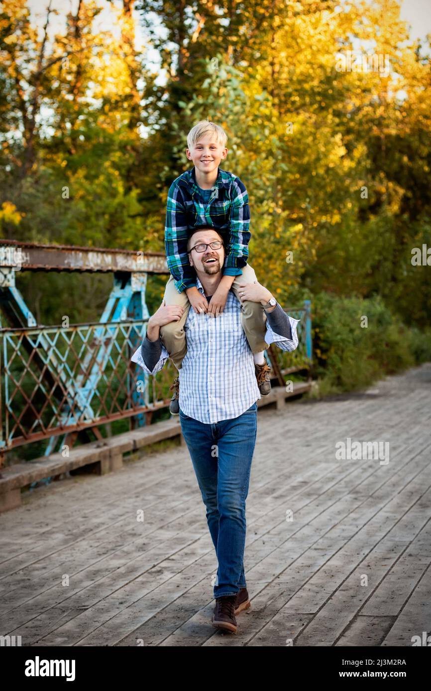 Father giving his son a shoulder ride in a park in autumn; Edmonton ...