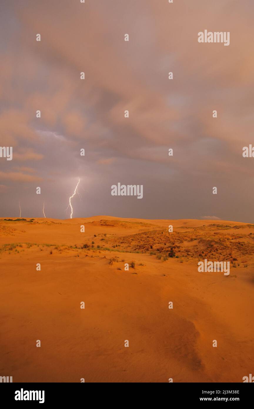 Lightning flashes above a sand dune in Jockey's Ridge State Park ...