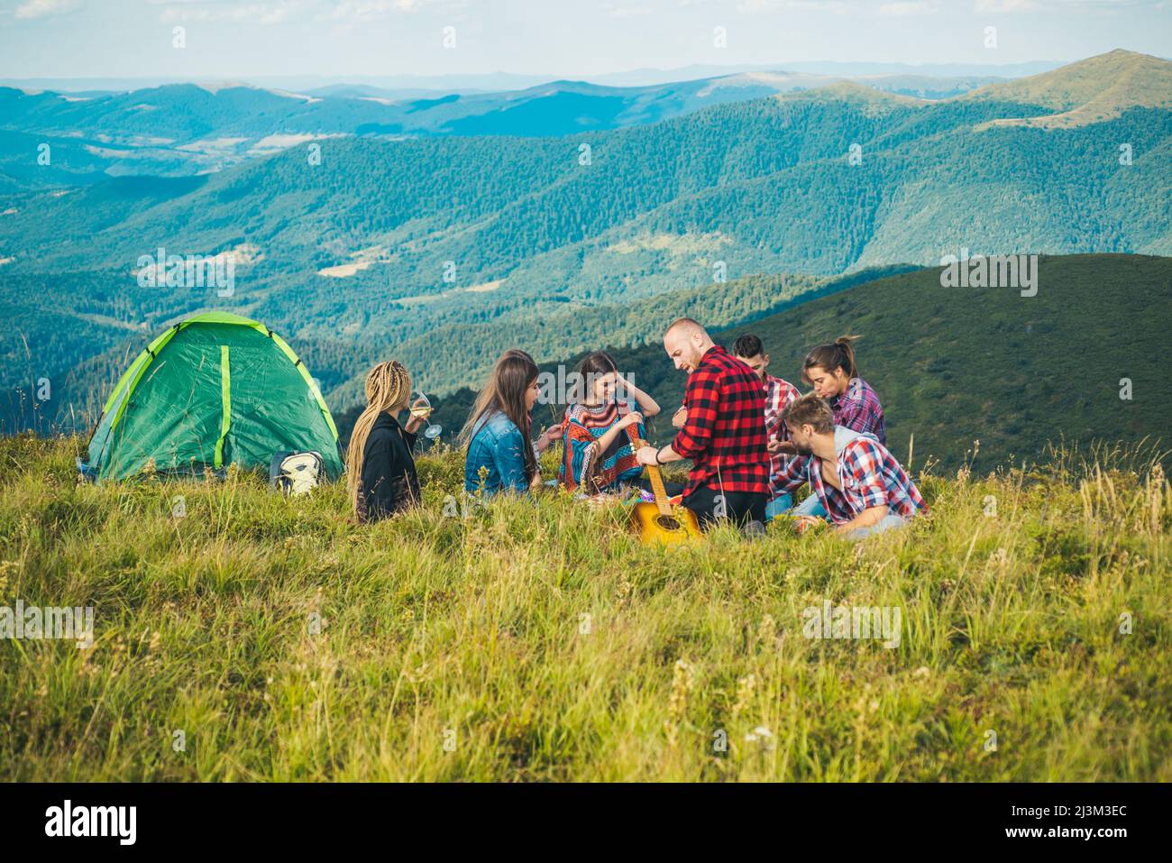 Young people rest in countryside. Group of friends on country walk ...