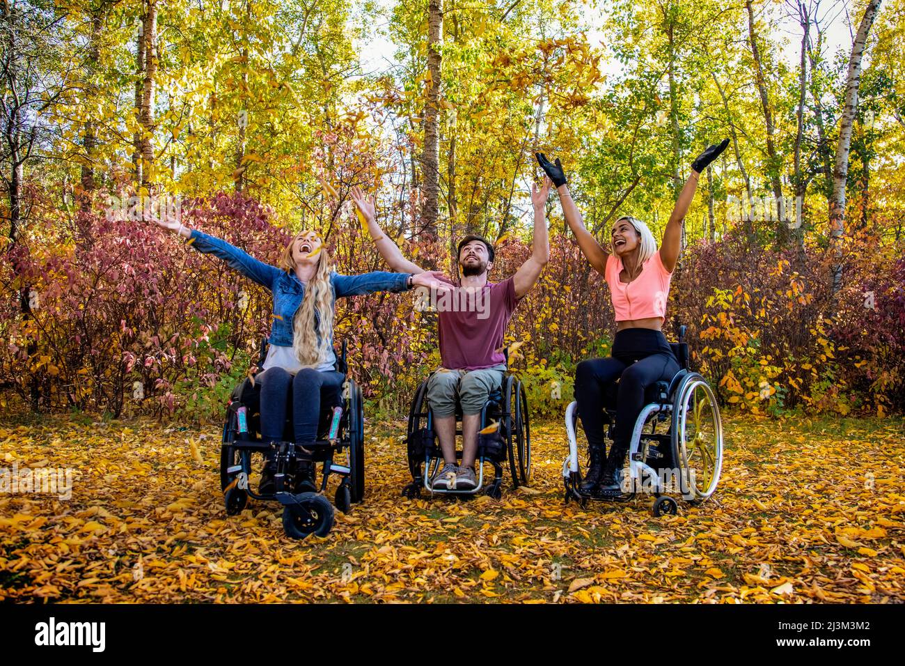 Group of three young paraplegics in their wheelchairs in a park on a ...