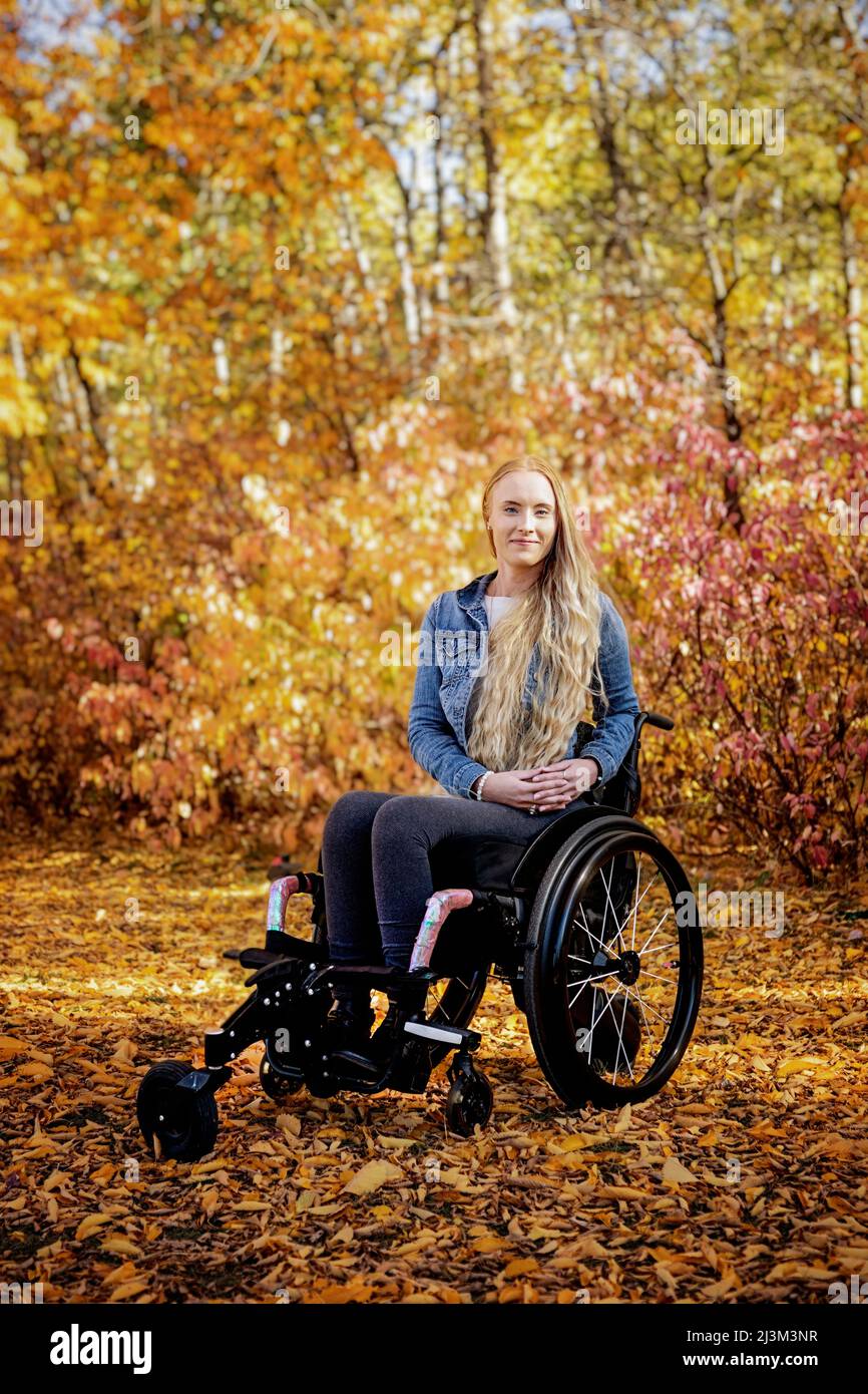 A young paraplegic woman in her wheelchair in a park on a beautiful ...