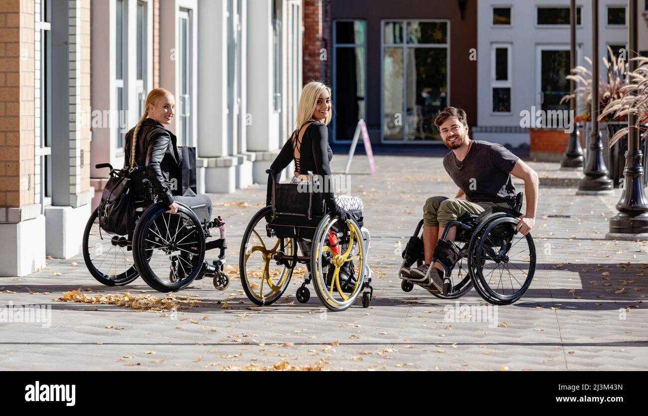 Three young paraplegic friends pose for the camera as they spend time ...
