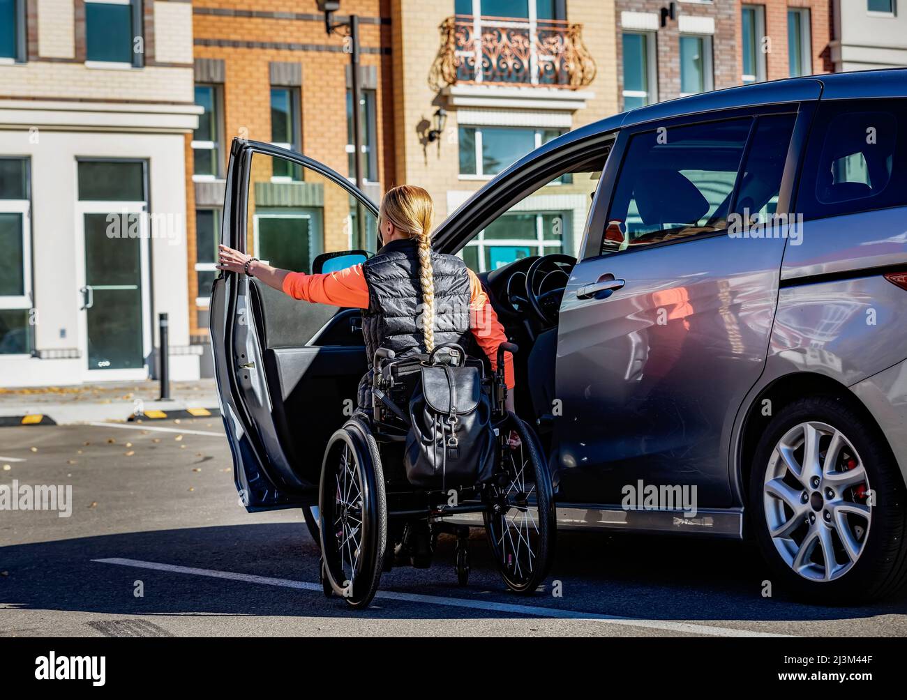 Young paraplegic woman moves from her wheelchair to the driver's seat ...