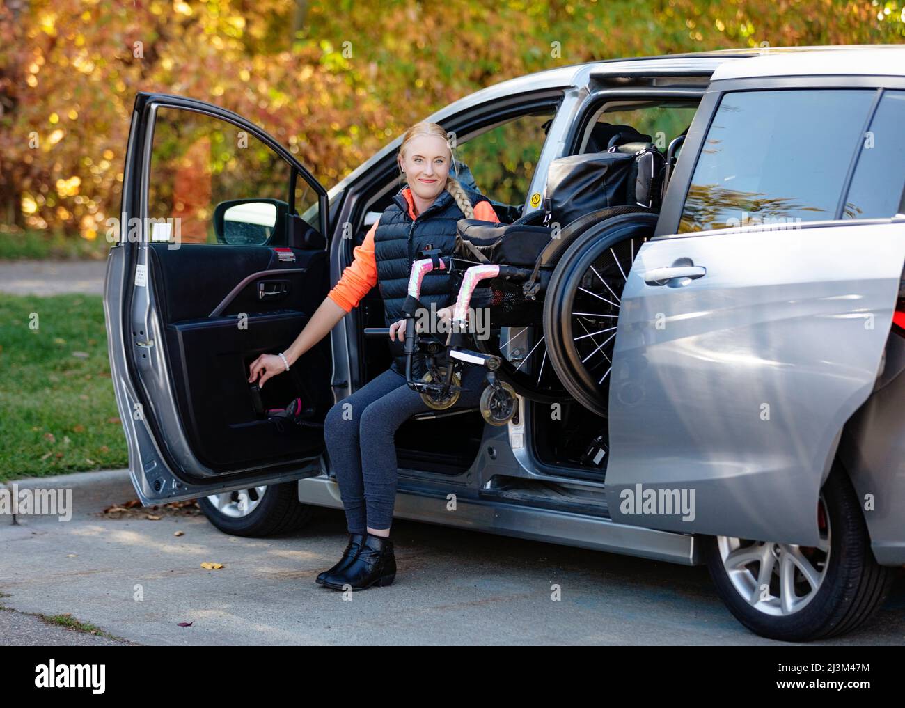 Young paraplegic woman moves from her wheelchair to the driver's seat ...