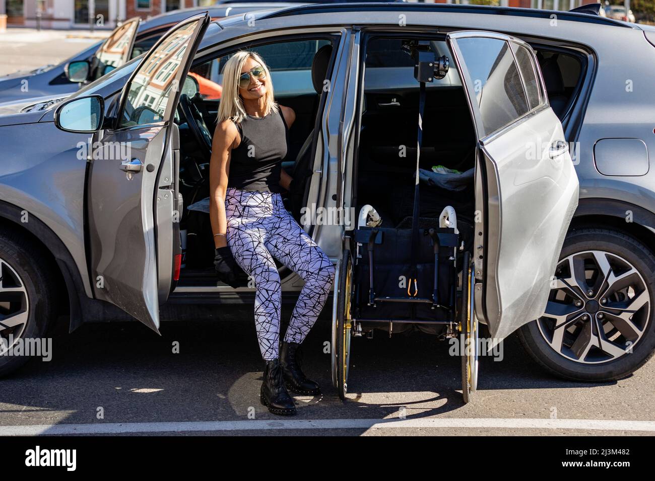Young paraplegic woman moves from her wheelchair to the driver's seat ...