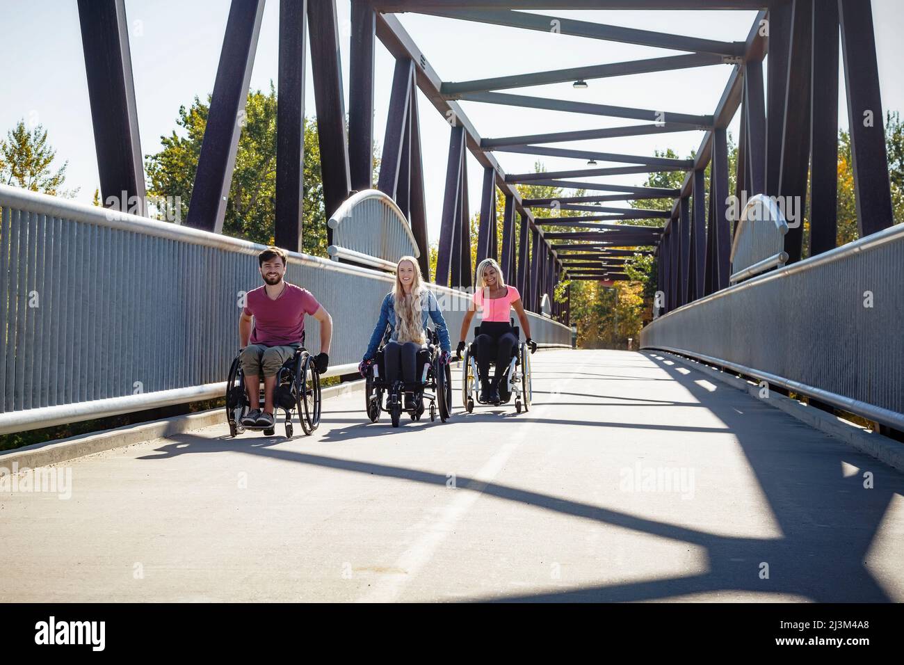 Three young paraplegic friends spending time together moving across a ...