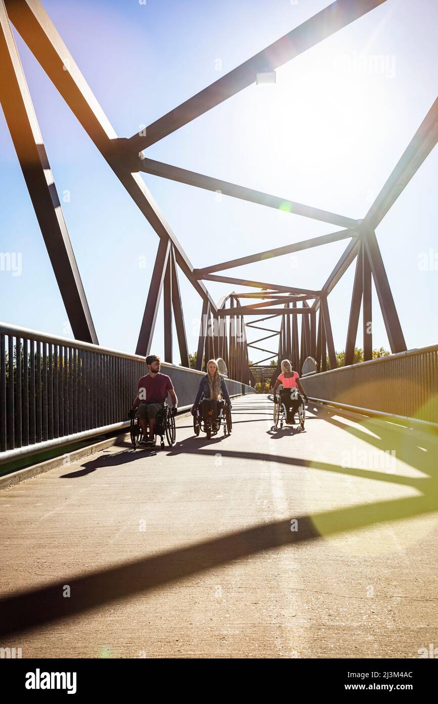 Three young paraplegic friends spending time together moving across a ...