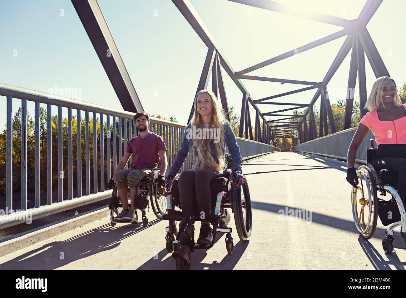 Three young paraplegic friends spending time together moving across a ...