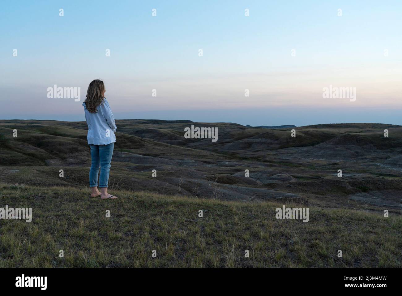 Woman viewing the sun setting over the prairies of Saskatchewan in ...