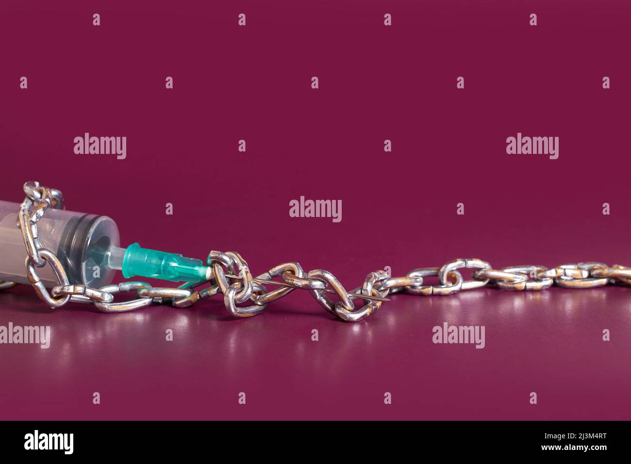 Drug addiction. An empty medical syringe is wrapped with a chain Stock ...