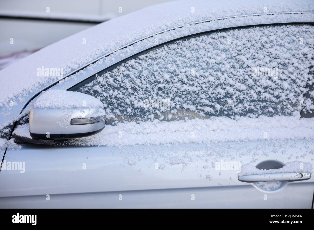 Car covered with a thin layer of fresh white snow. Side view Stock ...