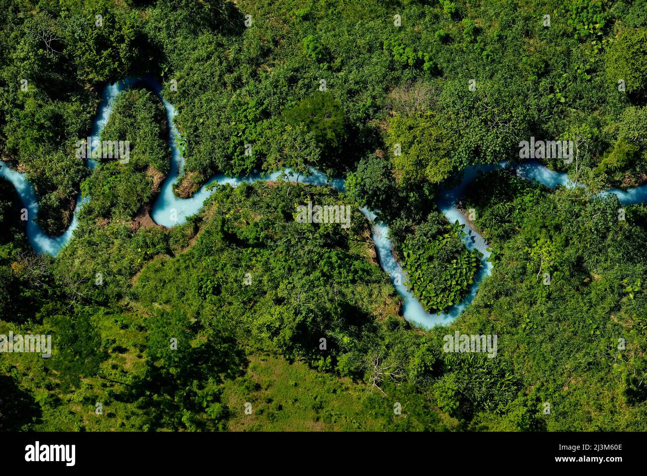A milky, blue sulphurous river flows through the vegetation outside ...