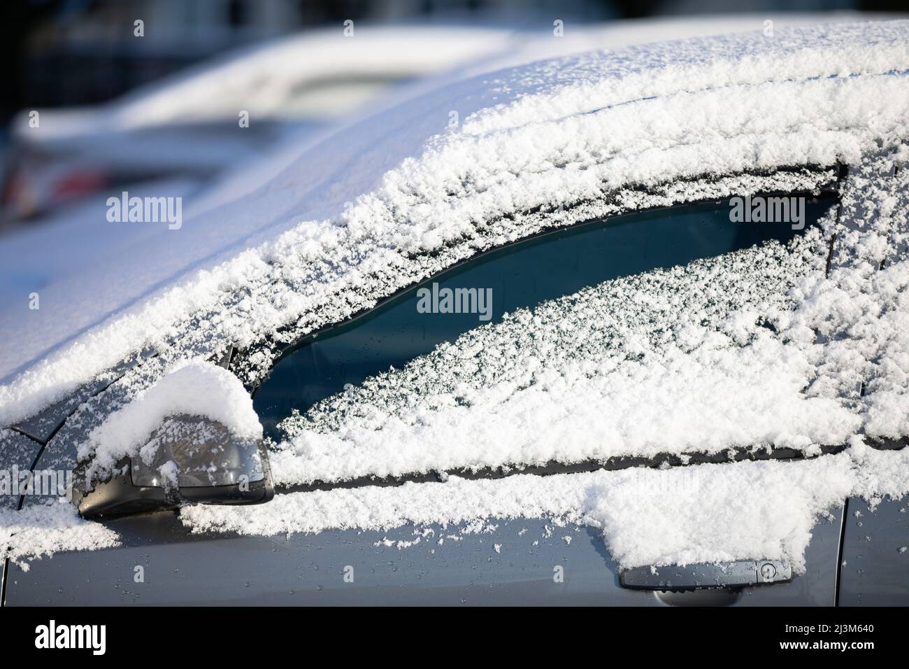 Car covered with a thin layer of fresh white snow. Side view Stock ...