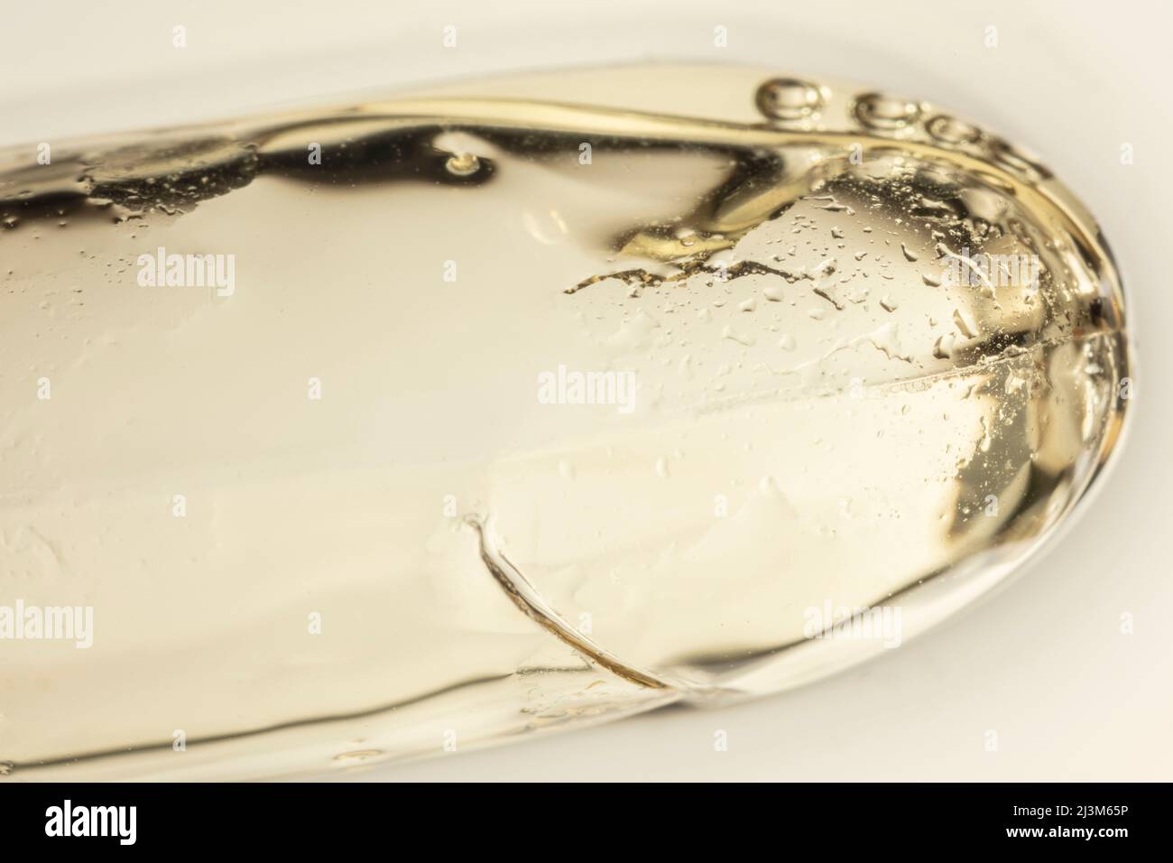 Macro photograph of burst Omega 3 capsule against a plain background ...