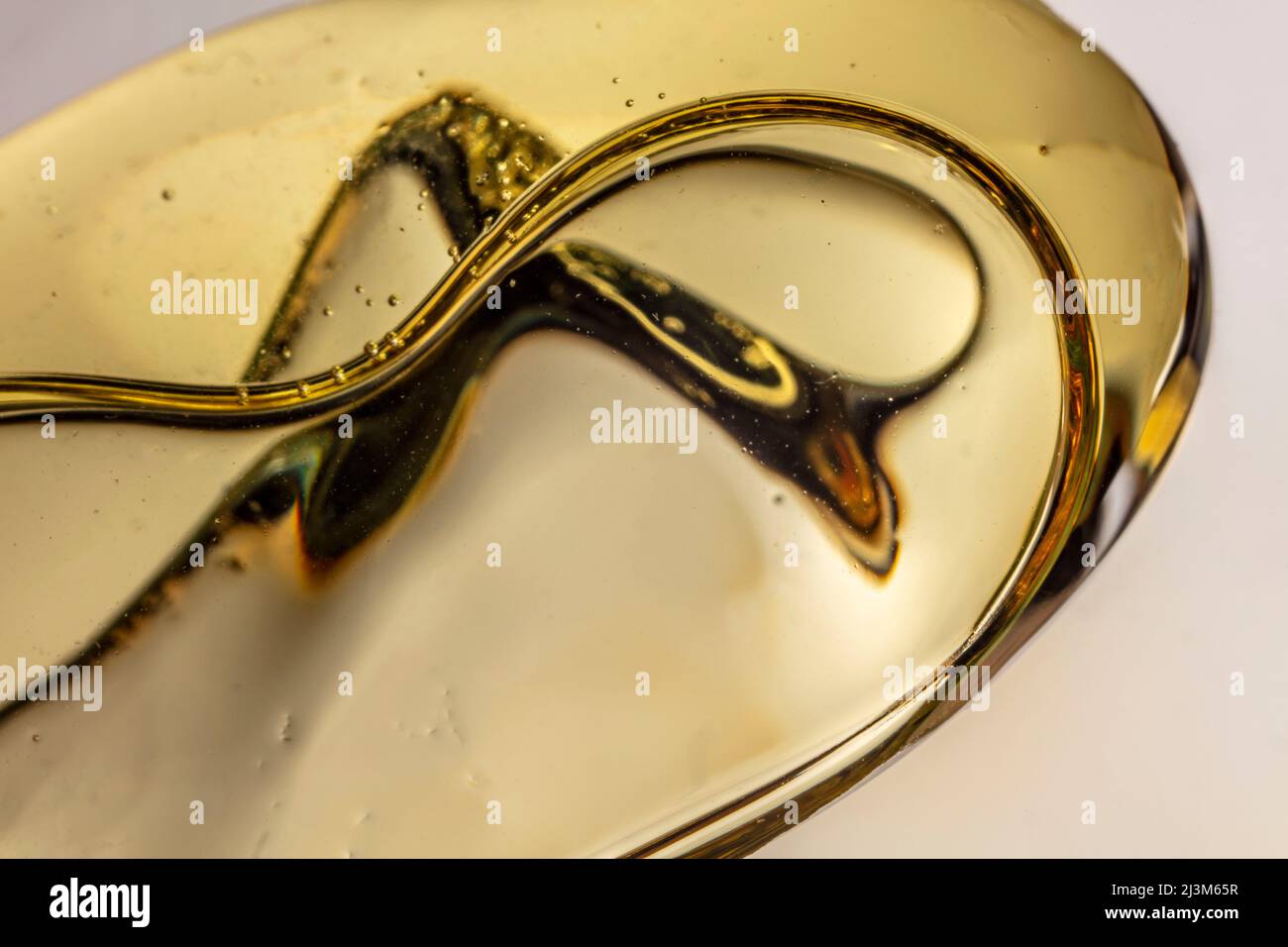 Macro photograph of burst Omega 3 capsule against a plain background ...