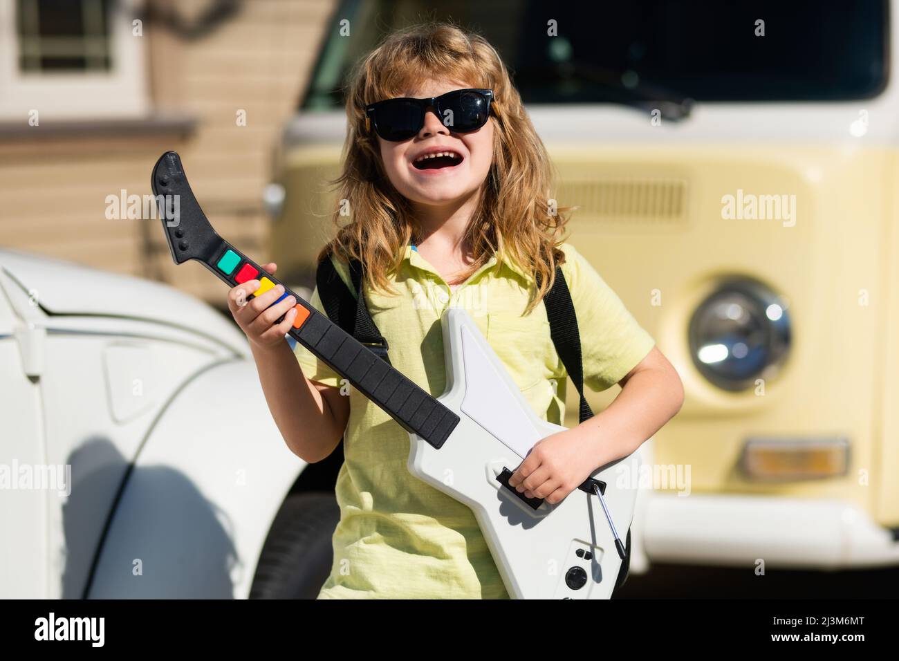 Excited kid boy with musical instruments. Caucasian little boy play ...
