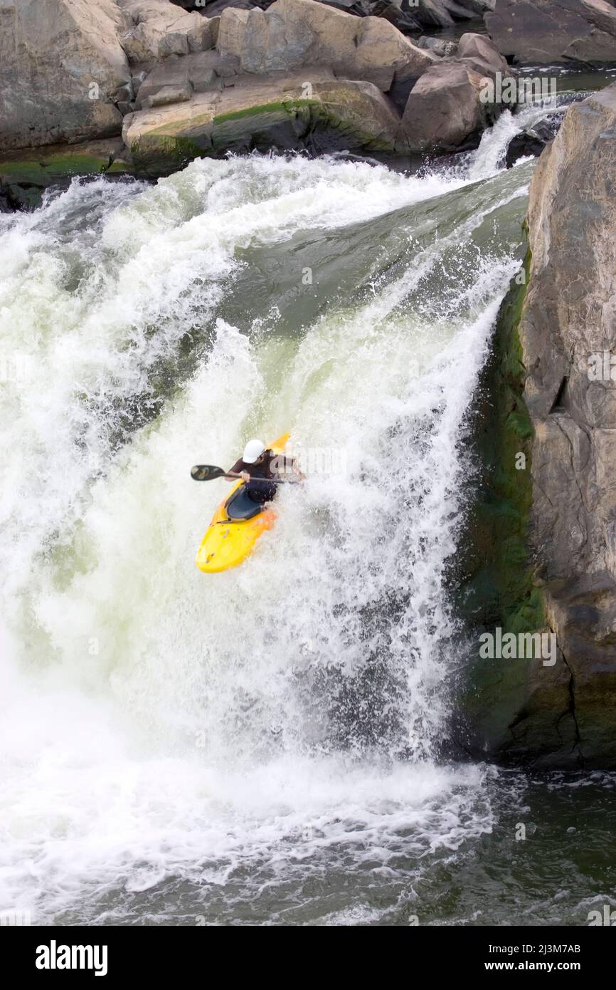 White water kayaker paddles off waterfall.; Potomac River, Maryland and ...