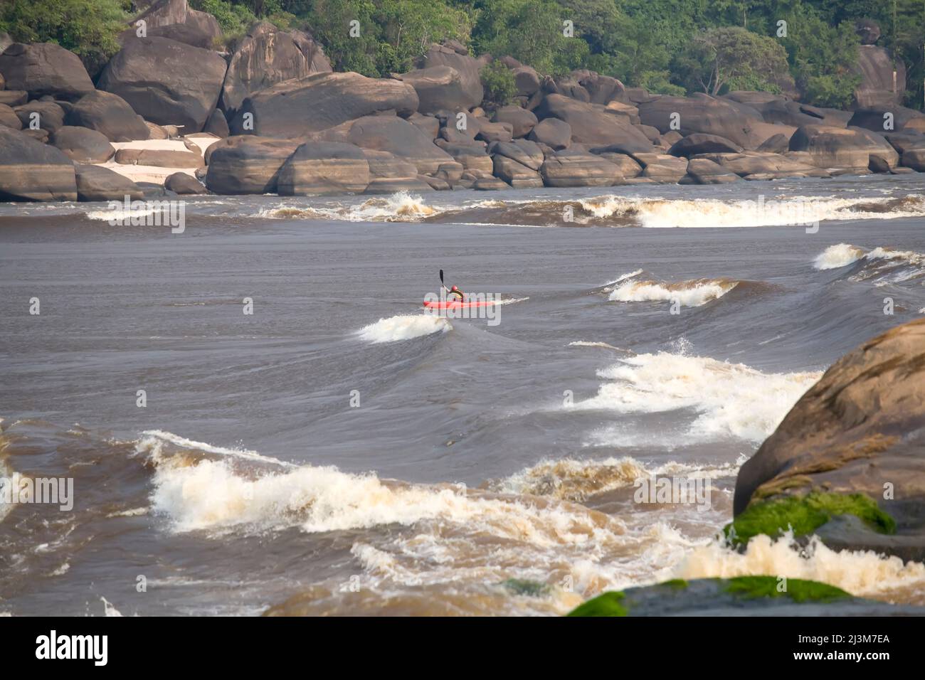 A kayaker paddles through a wave train approaching another rapid ...