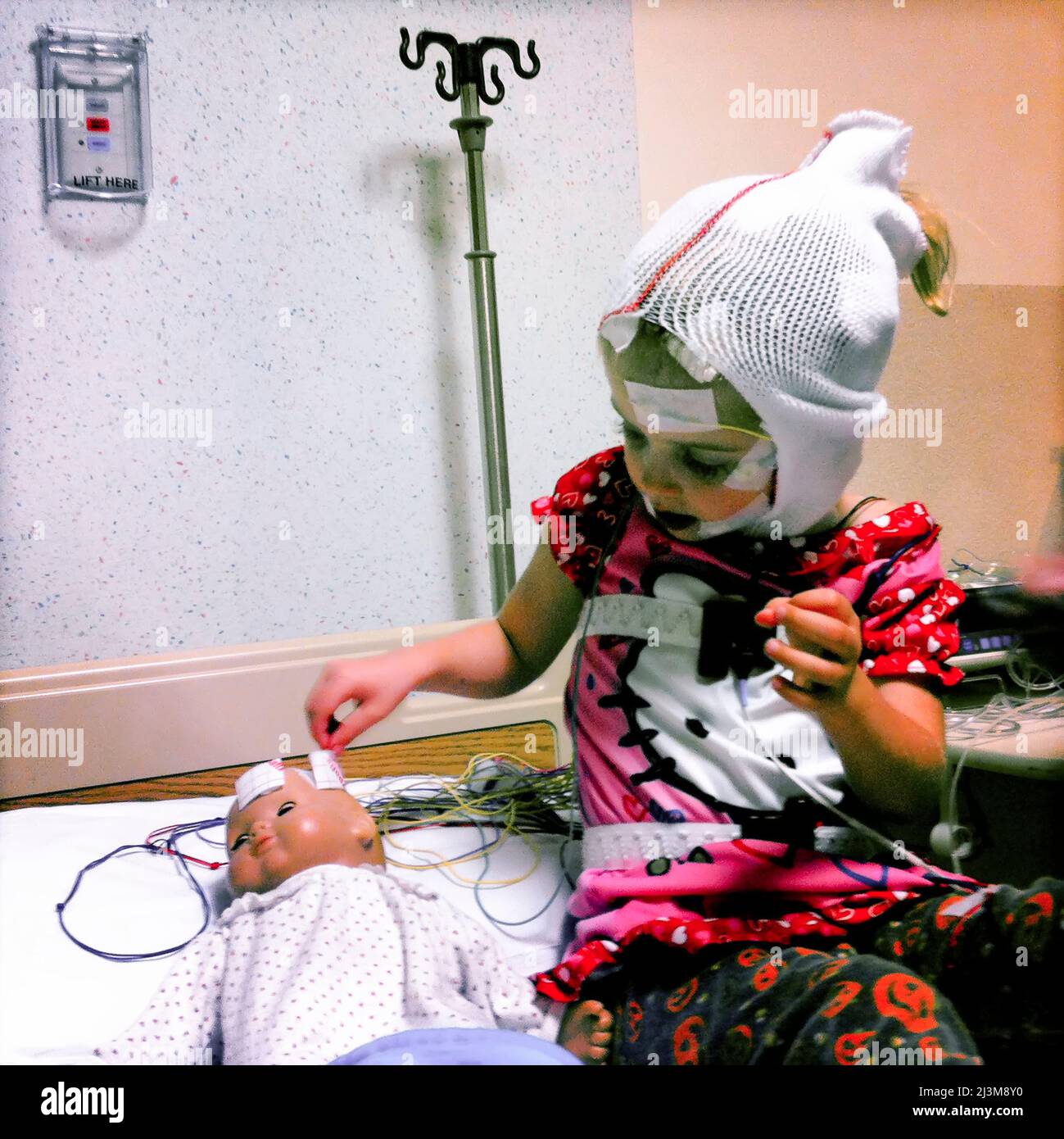 A three year old girl prepares for sleep study with her doll at ...