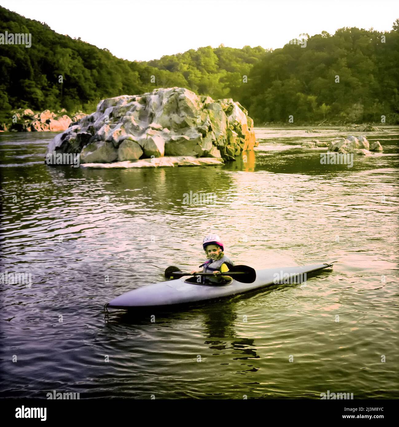 A three year old girl paddles her kayak on the Potomac River.; Potomac ...