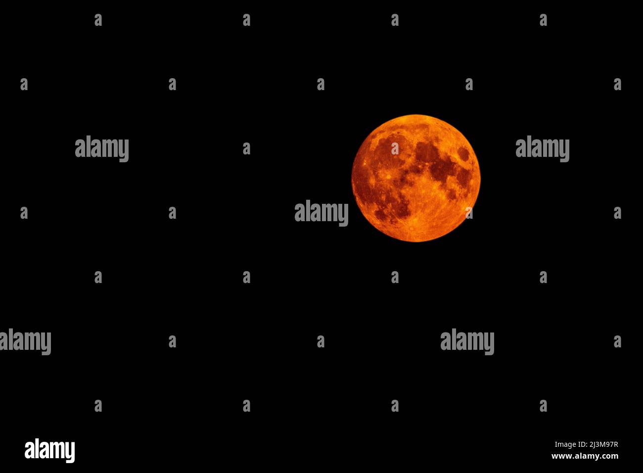 Glowing orange full moon in the black sky; Calgary, Alberta, Canada ...