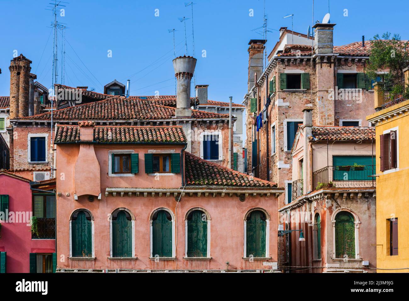 Traditional Venetian buildings in a colourful setting under a blue sky ...