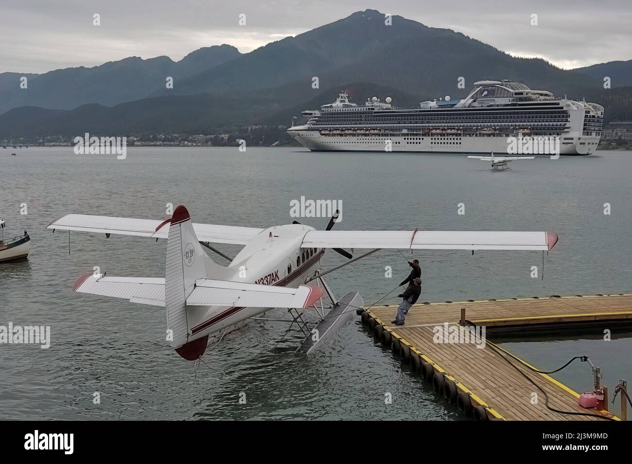 Float planes dock to board and carry tourists, then take off over ...