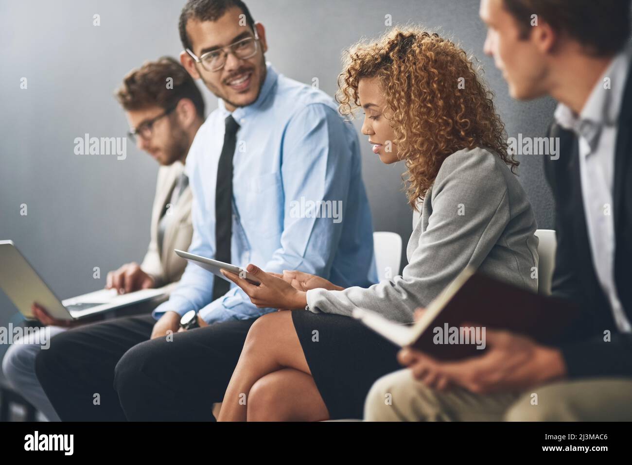 Making connections while in line. Shot of a group of businesspeople ...