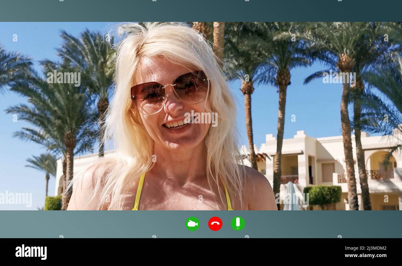 woman on the street among the palm trees talking by video link. Sunny day and blue sky Stock ...