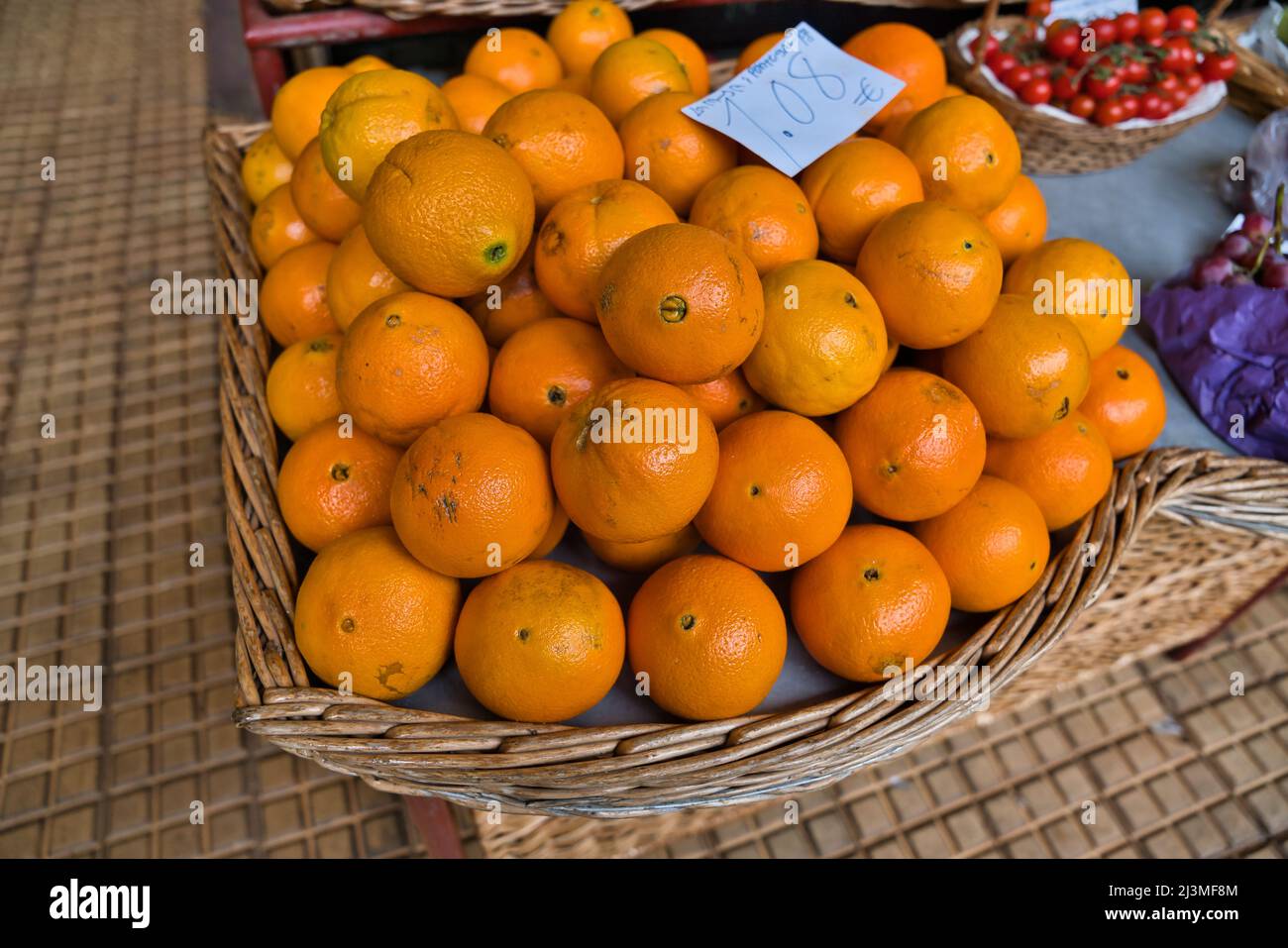 A lot of fresh Orange fruits in big wicker basket on the traditional ...