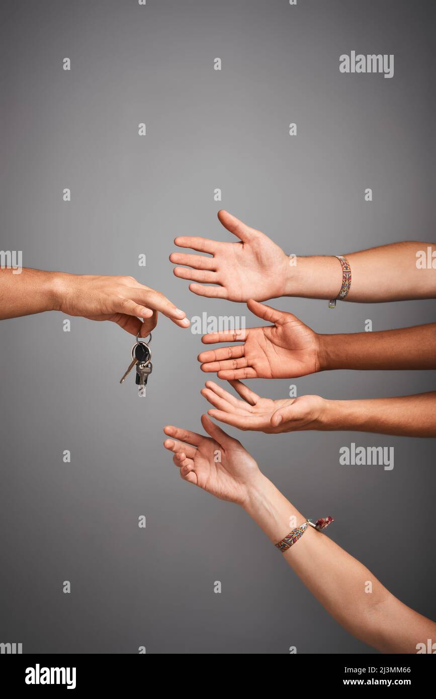 Who wants to drive. Studio shot of unidentifiable hands reaching for a ...