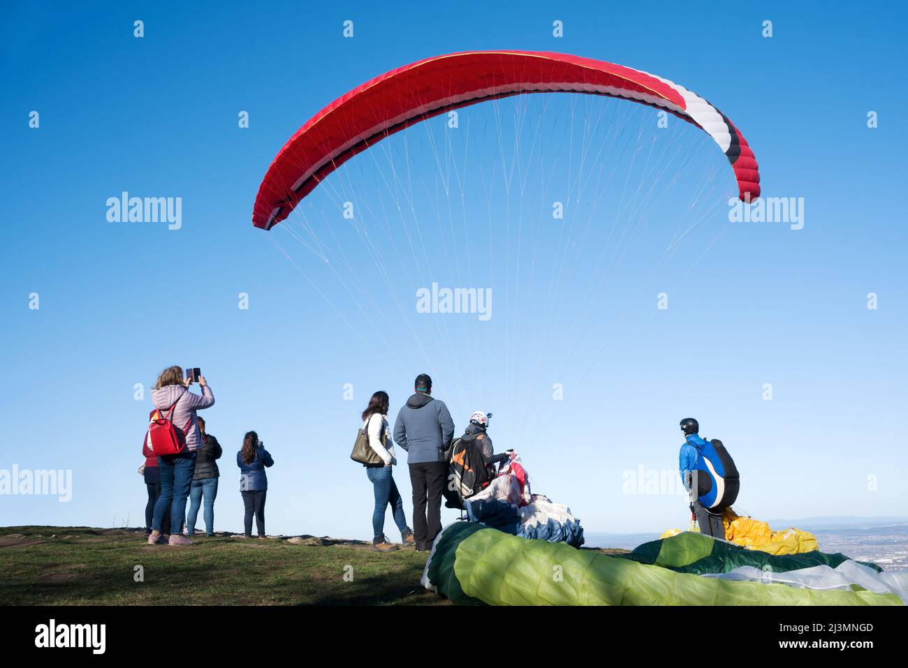 People watching paraglide take off Stock Photo - Alamy