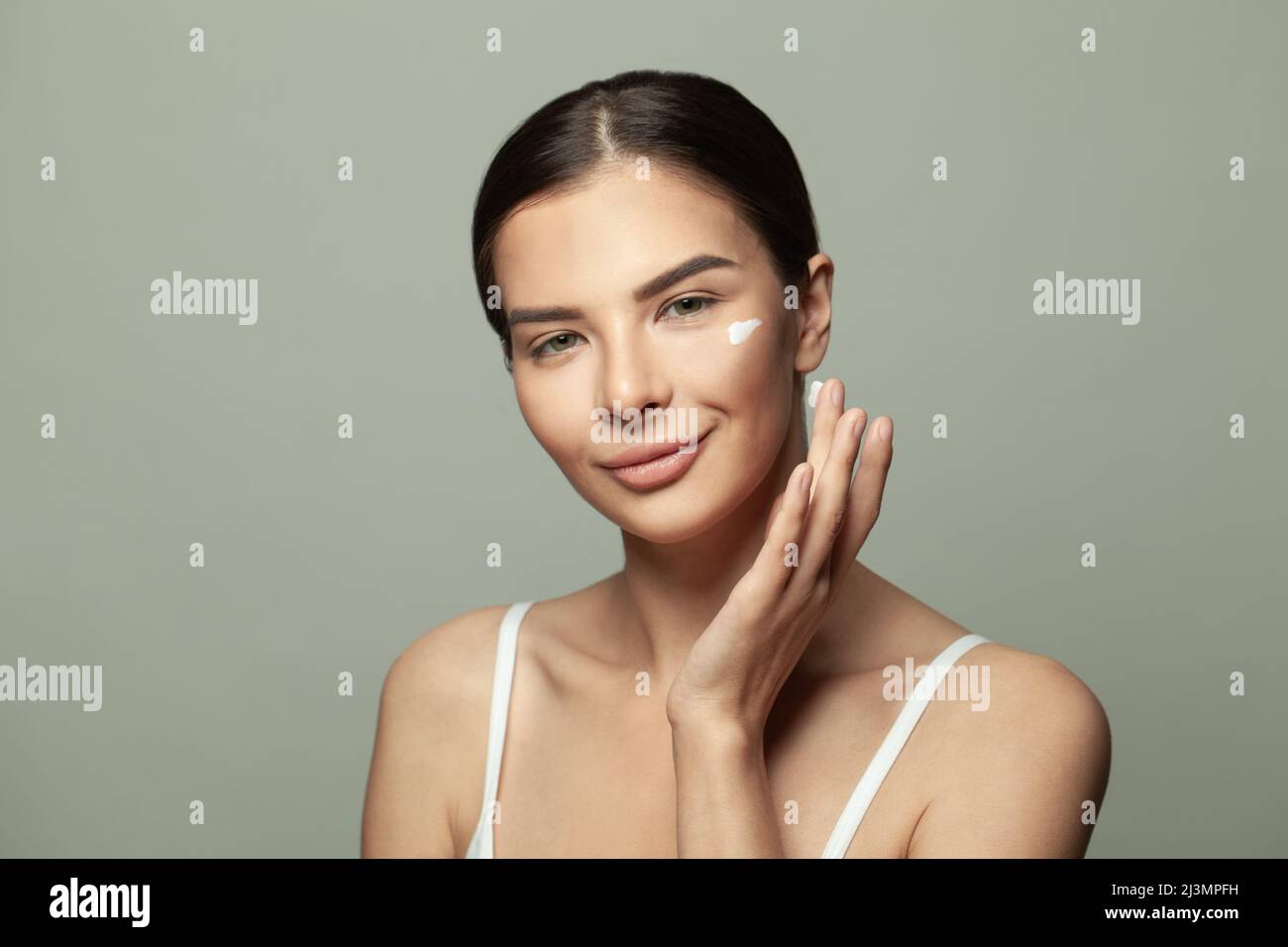 Beauty Model with Perfect Fresh Skin applying Face Cream. Spa and ...