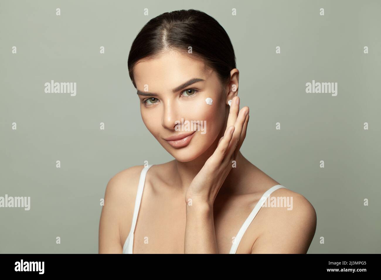 Young woman with creame on her face on white background Stock Photo - Alamy