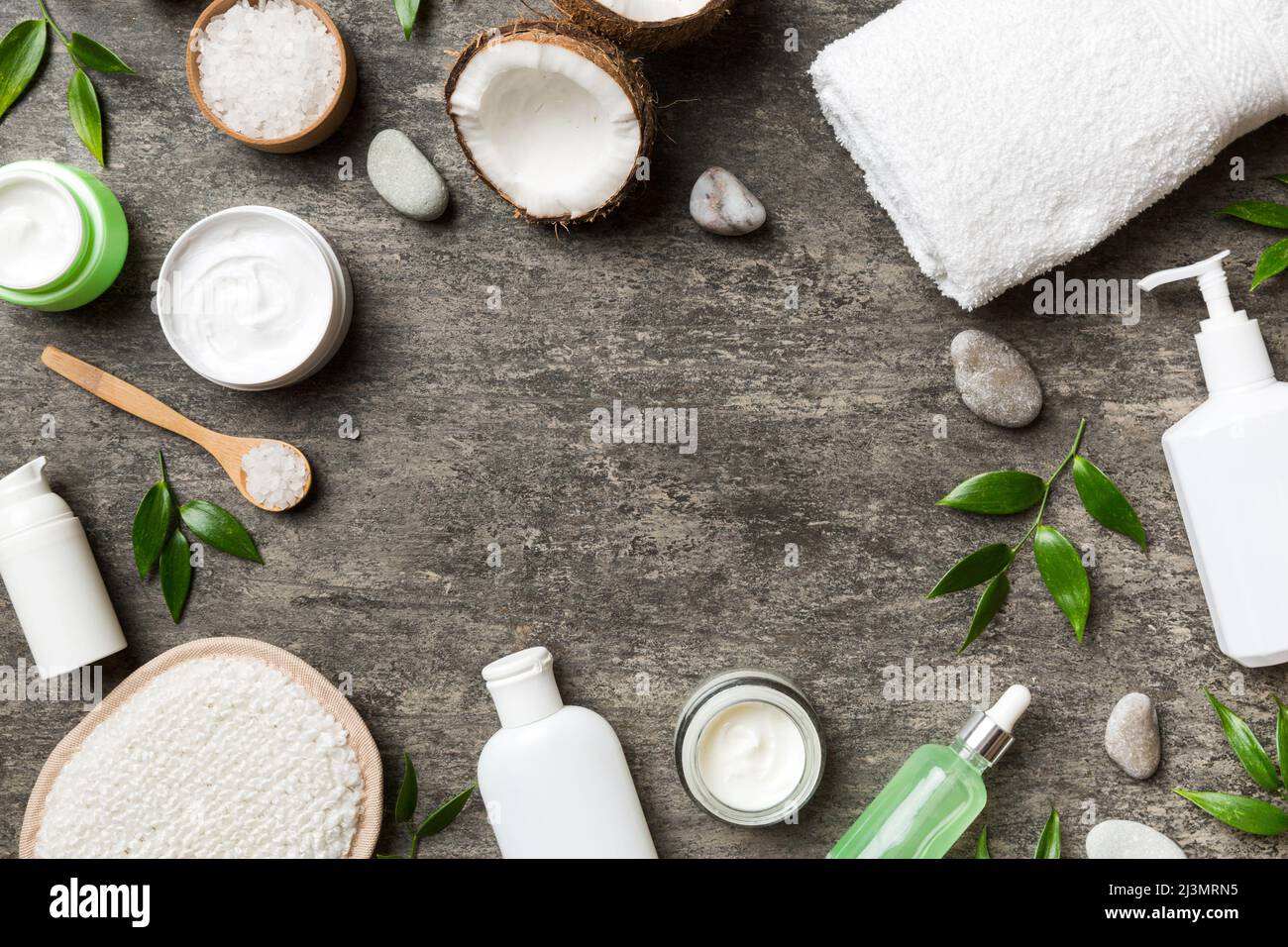Coconut with jars of coconut oil and cosmetic cream on colored ...