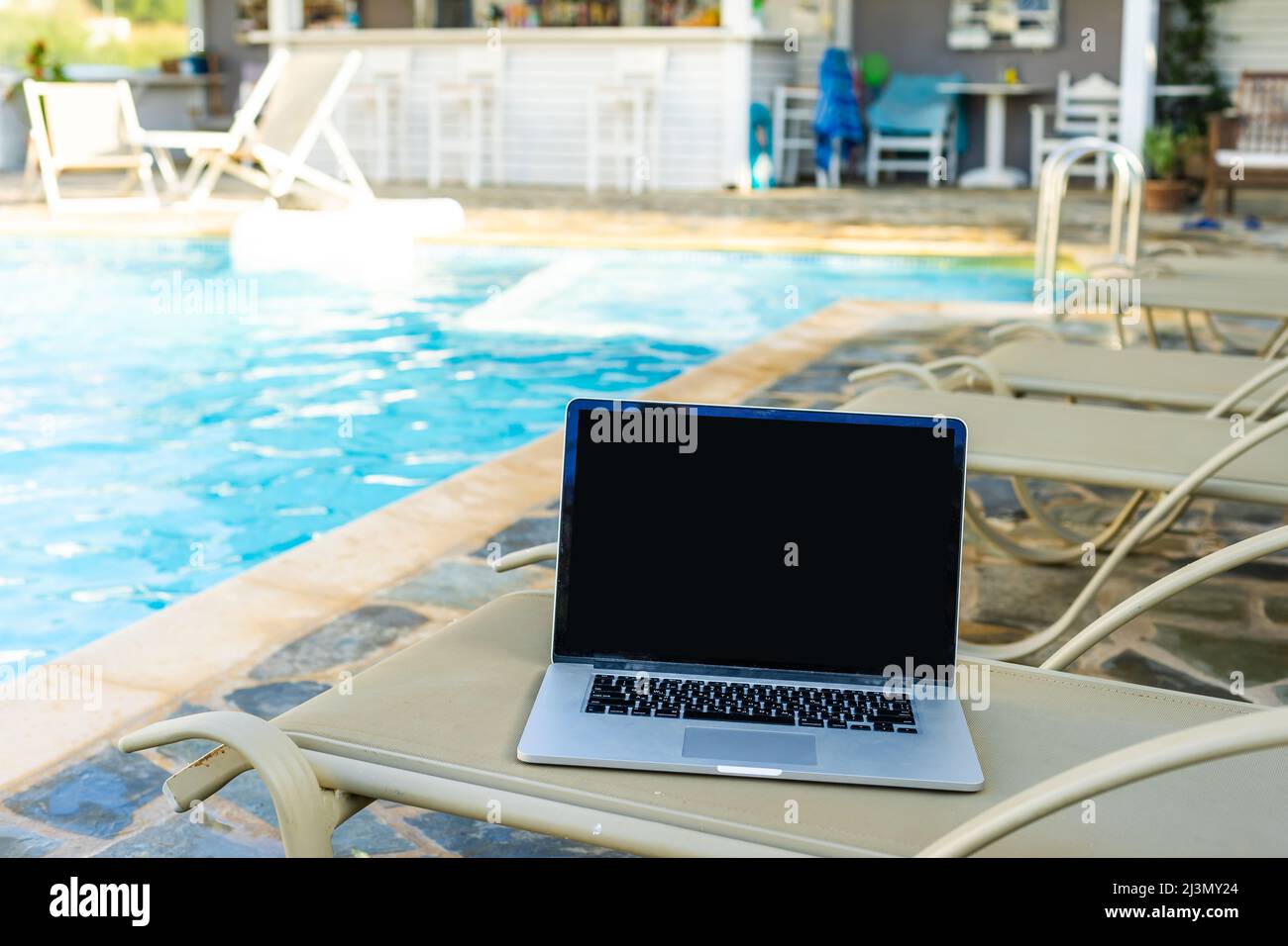 laptop on a sun lounger by the pool Stock Photo - Alamy