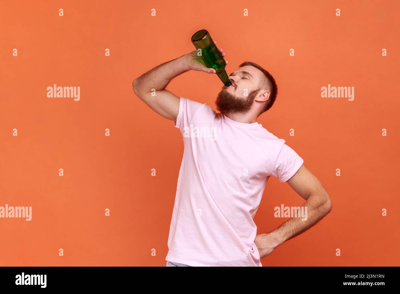 Portrait of bearded man standing with beer bottle, being drunk ...