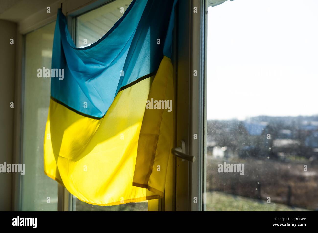 Flag of Ukraine on the window sealed with tape. No war. War in Ukraine ...