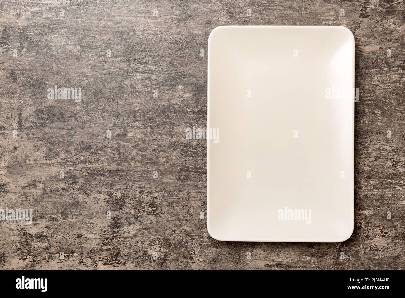 Top view of empty square plate on cement background. Empty space for ...
