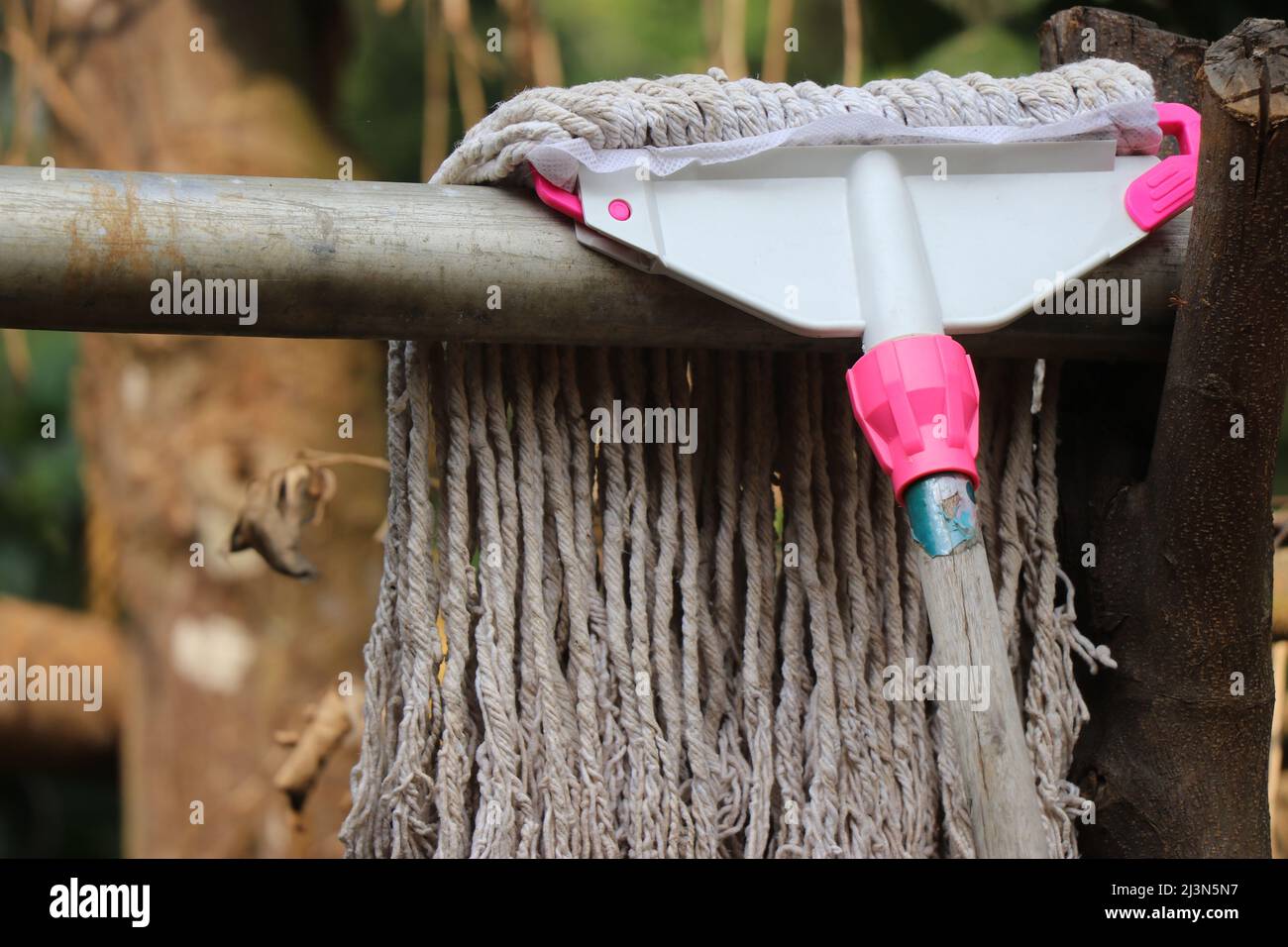 Old and dirty wooden handle mop kept for drying outdoors Stock Photo ...