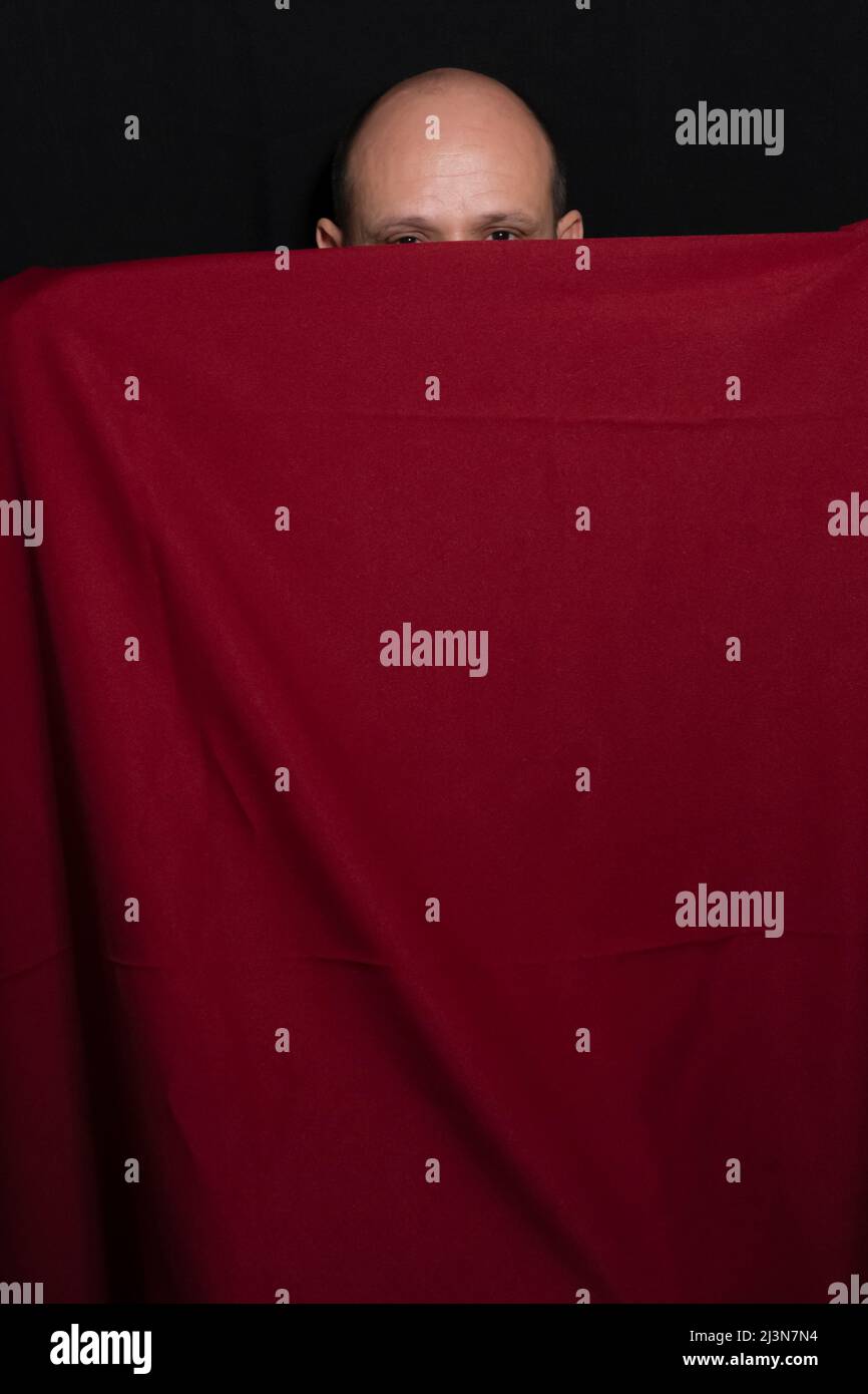 Man covered with red cloth against a black background. Salvador, Bahia ...
